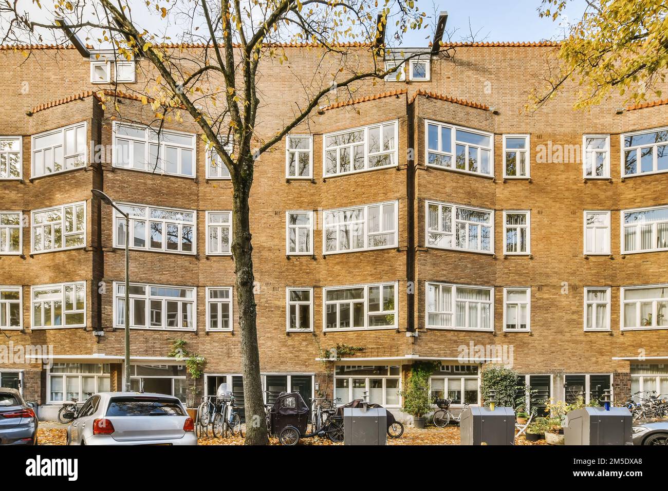an apartment building with cars parked on the street next to it and two ...