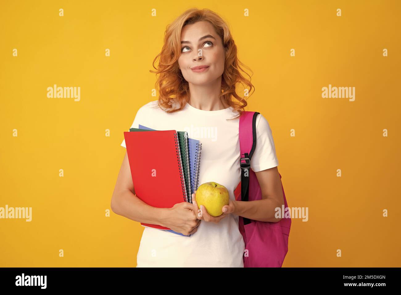 Surprised fun teen student girl with backpack on pastel yellow color ...