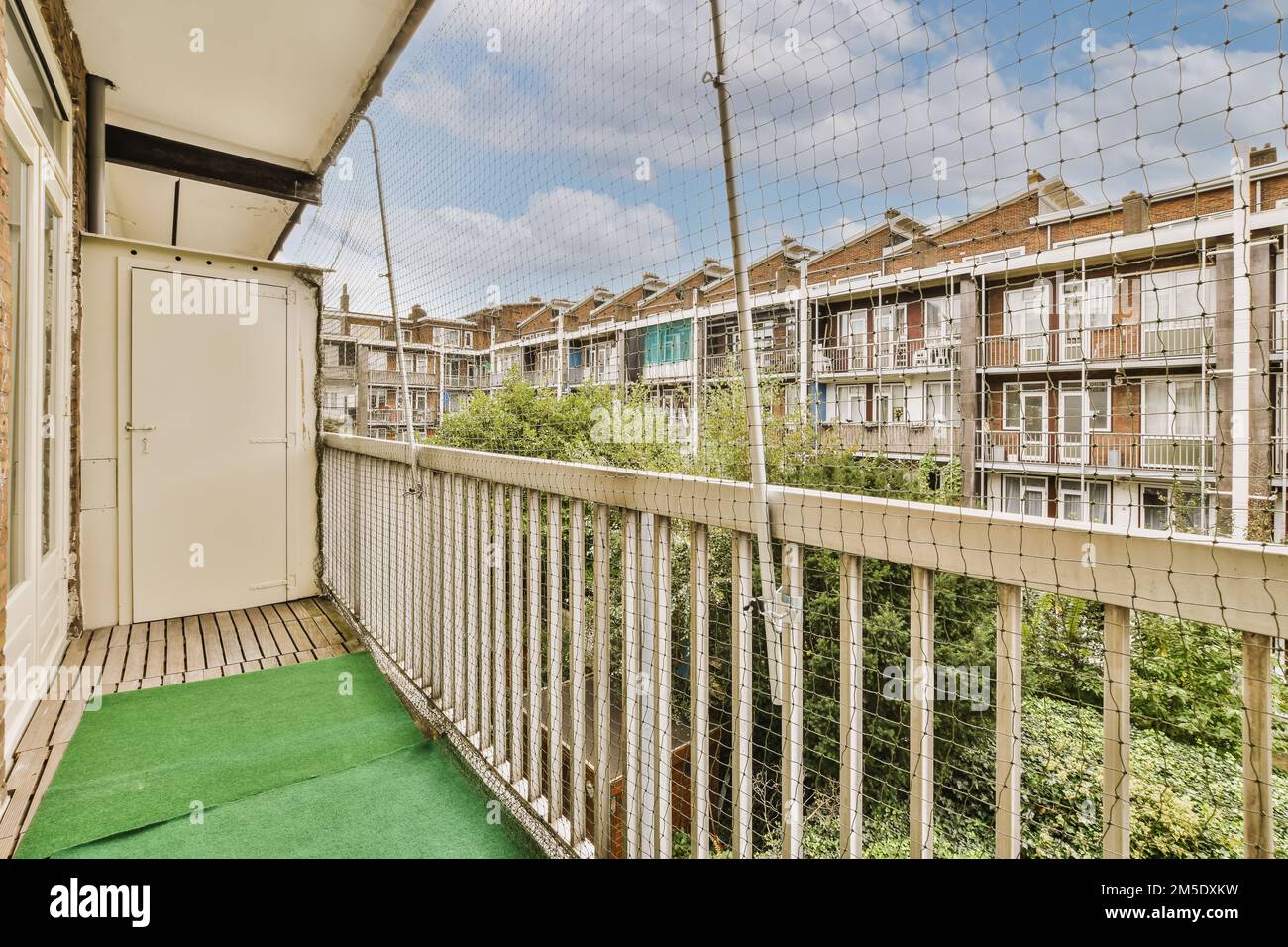 a balcony with green grass and fenced in the fore - image is taken from ...