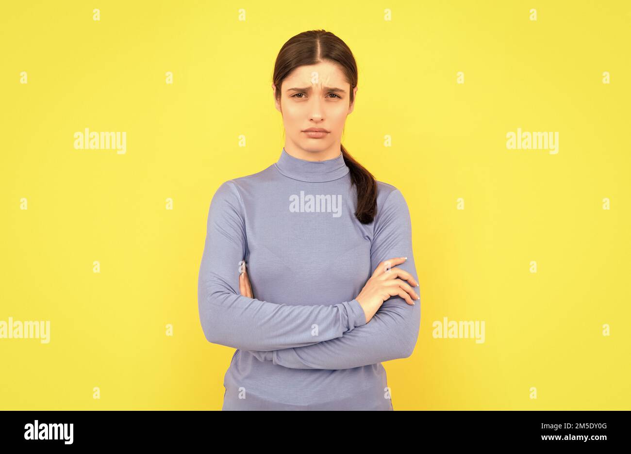 upset woman portrait crossed hands on yellow background, negative ...