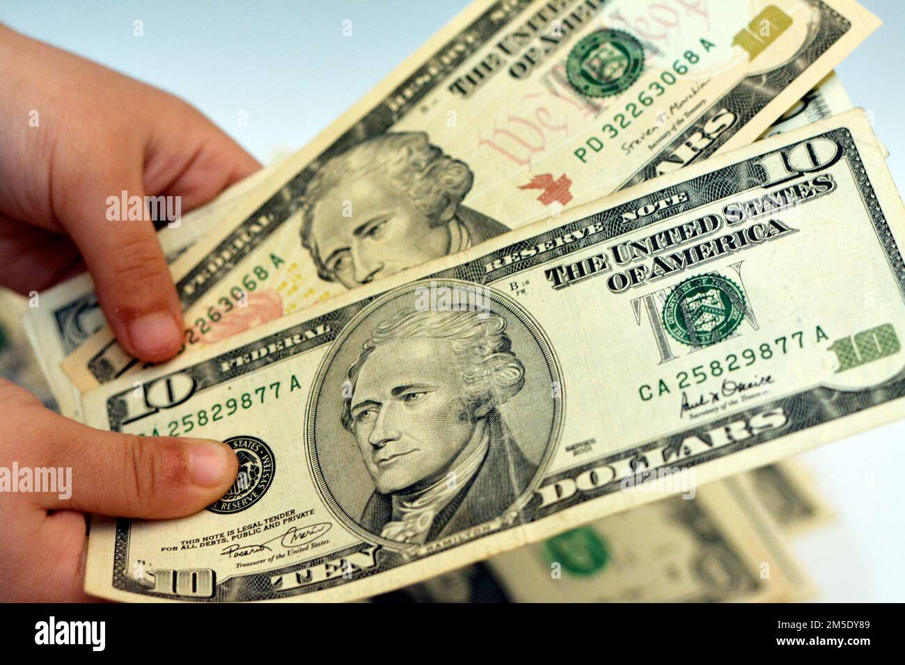 Ten 10 American dollars banknote money bill in the hand of a young ...