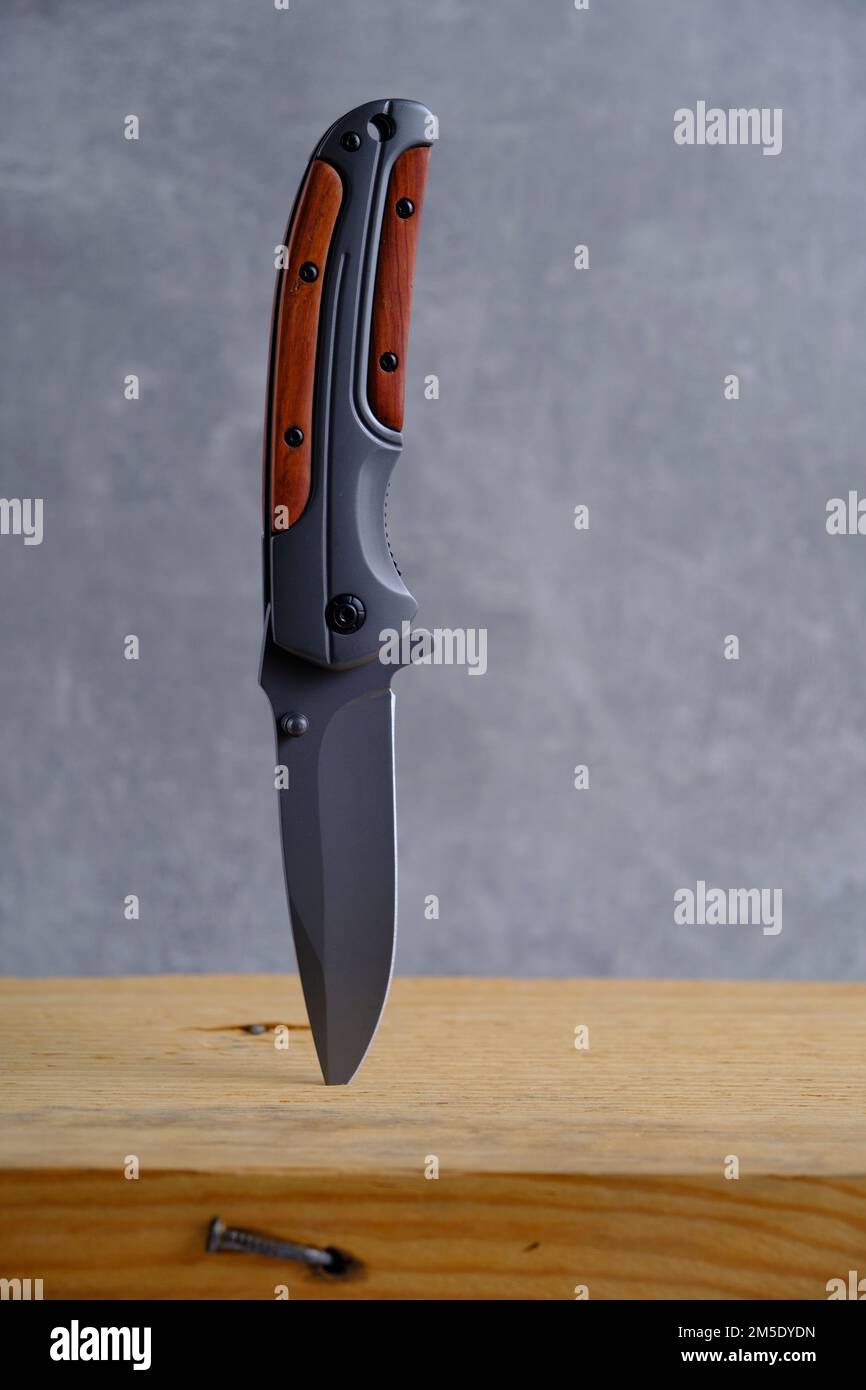 Folding knife for survival stuck wooden beam, on dark background Stock ...
