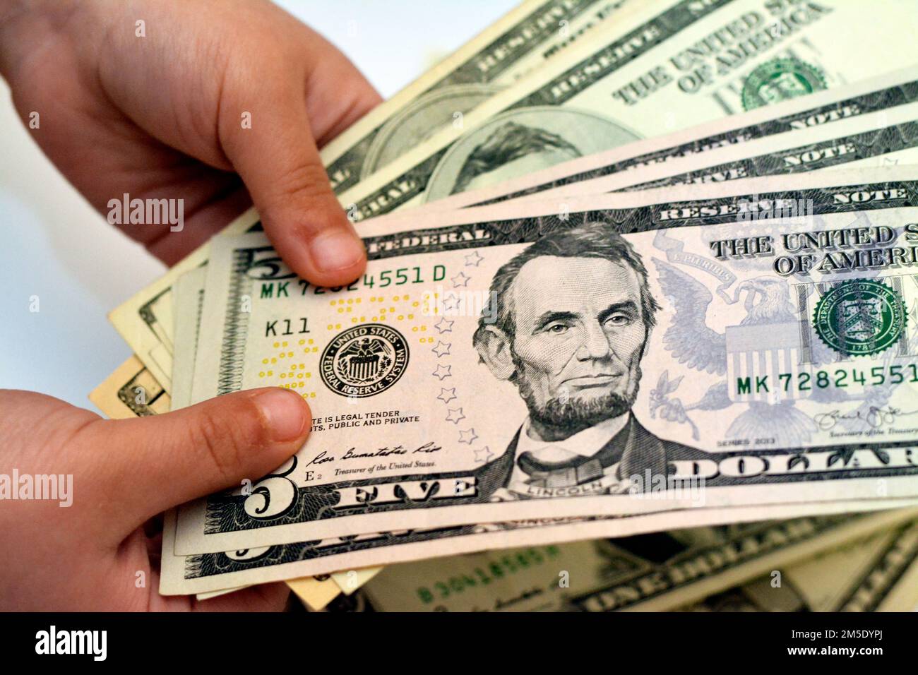 Five 5 American dollars banknote money bill in the hand of a young ...