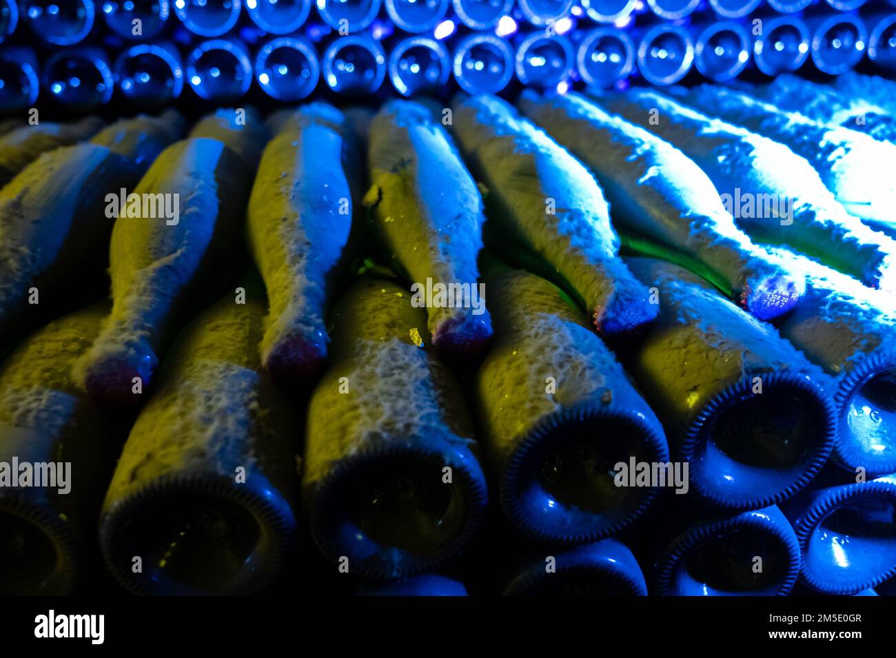 Old dusty glass bottles in pile of champagne bottles during of ...