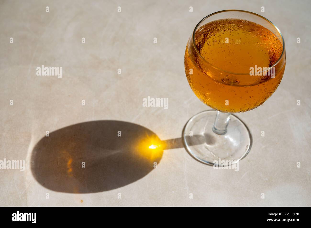Glass of of French apple sparkling cider on plastic table in outdoor ...