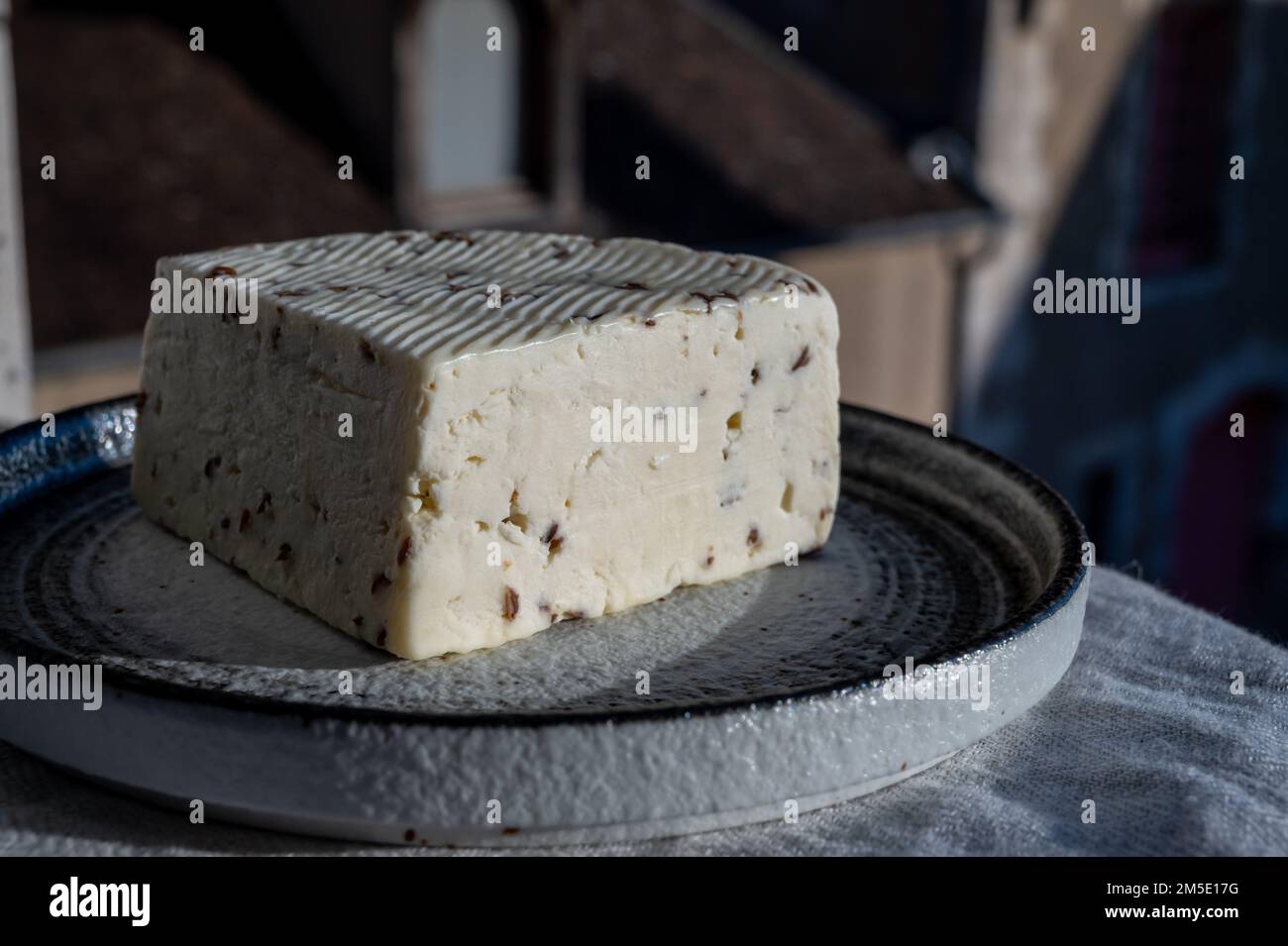 Piece of white sheep cheese with aromatic black cumin seeds served ...