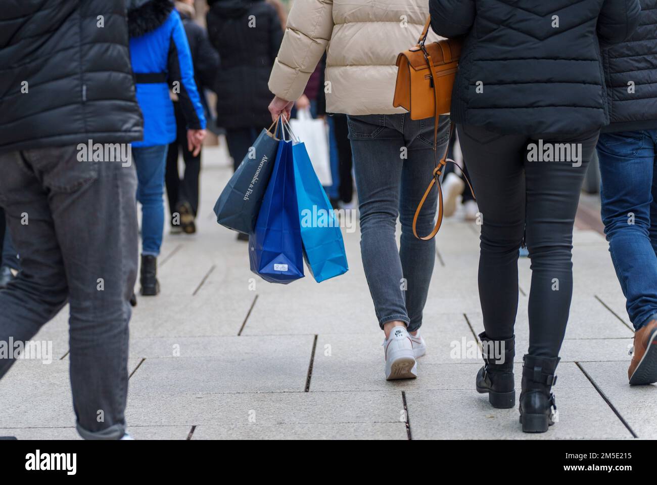 28 December 2022, Hessen, Frankfurt/Main: A man walks with shopping ...