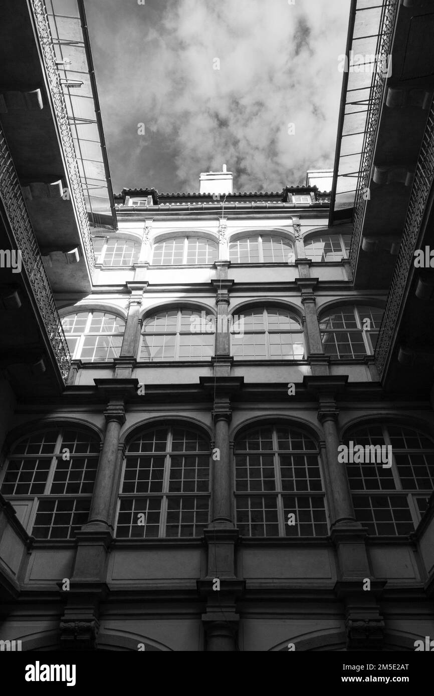 A grayscale low angle of a facade of a building with arch pattern glass ...