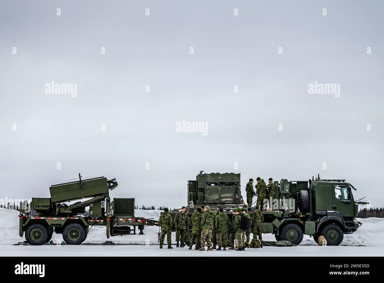 Canadian Army soldiers prepare a mack load handling system and a mid ...