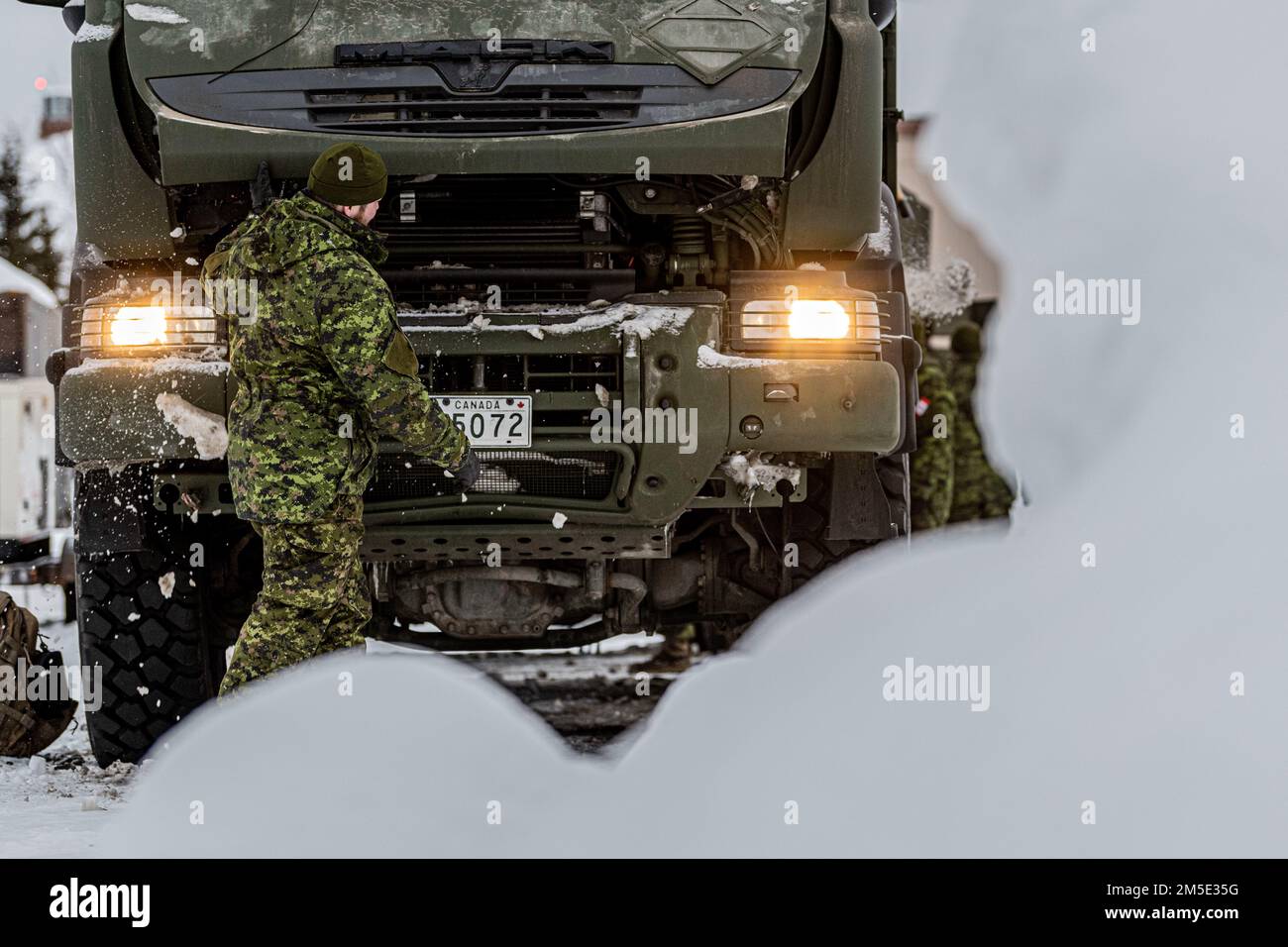 A Canadian Army soldier opens the hood of a mack load handling system ...