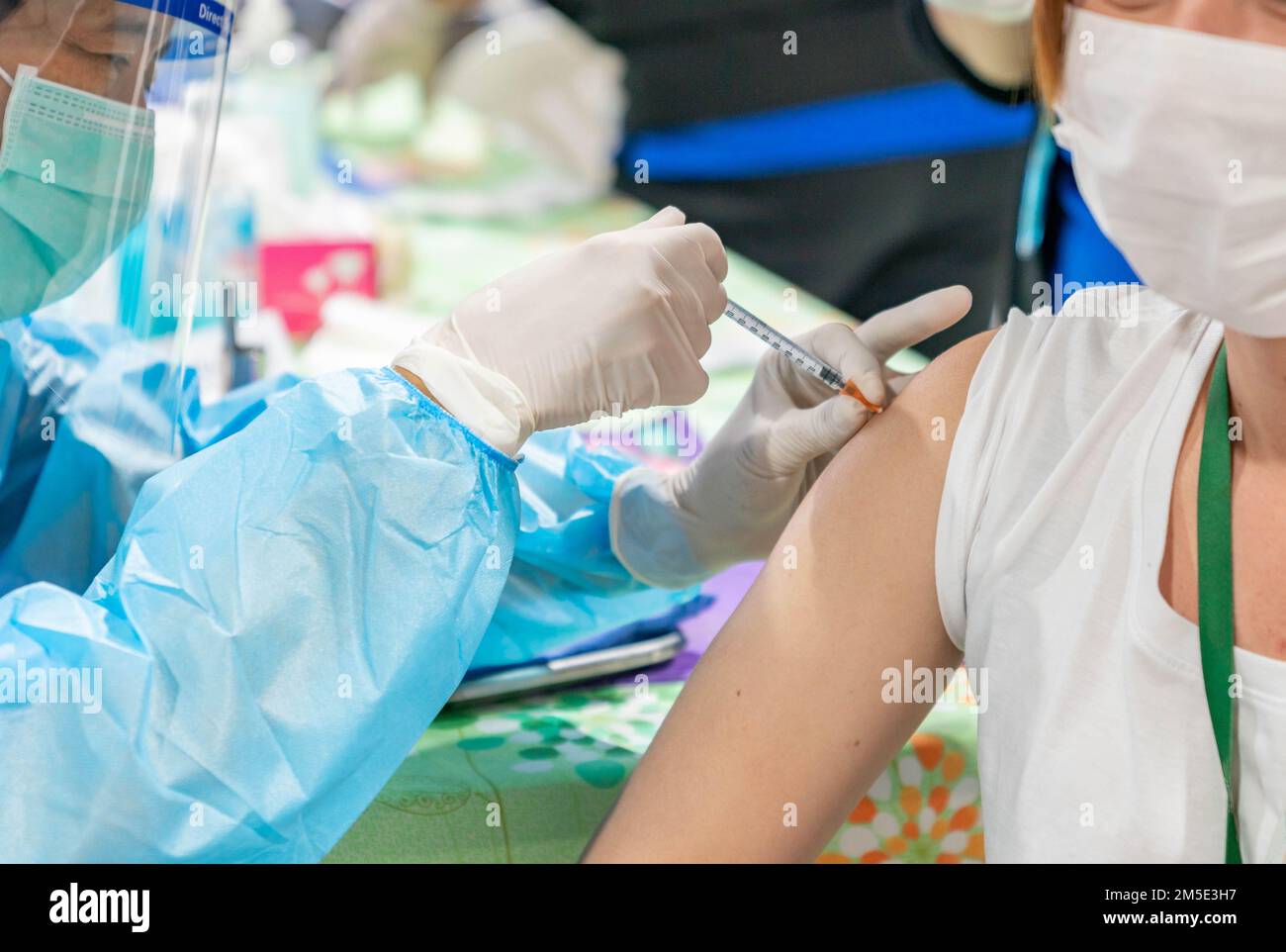 General practitioner vaccinating young woman in clinic. Doctor giving ...