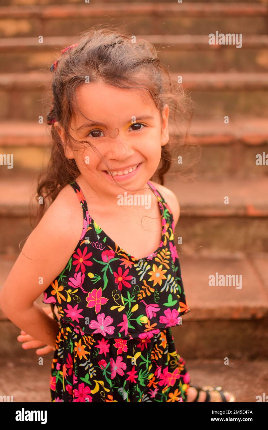 A vertical shot of a little Spanish kid with a cute face posing for a ...