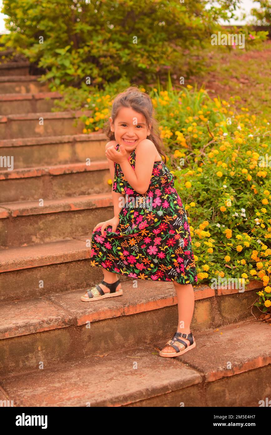 A little Spanish kid with a cute face posing for a picture in a park ...