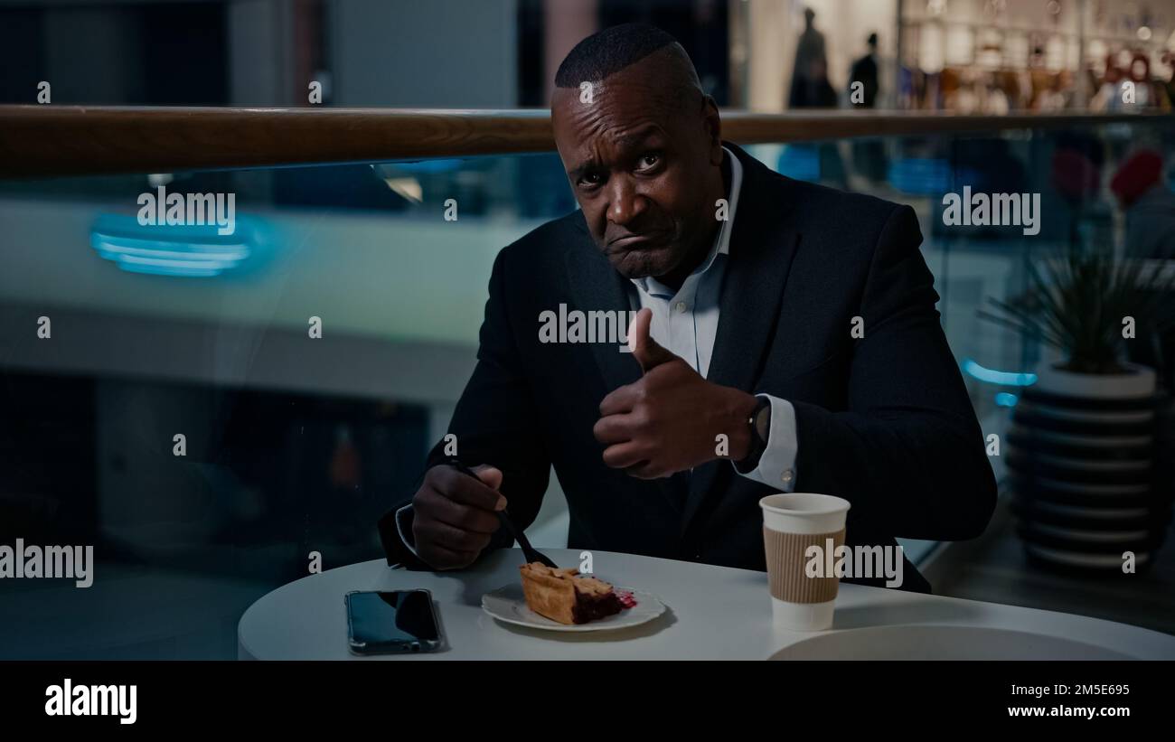 Ethnic middle-aged businessman entrepreneur cafe visitor eating pie ...