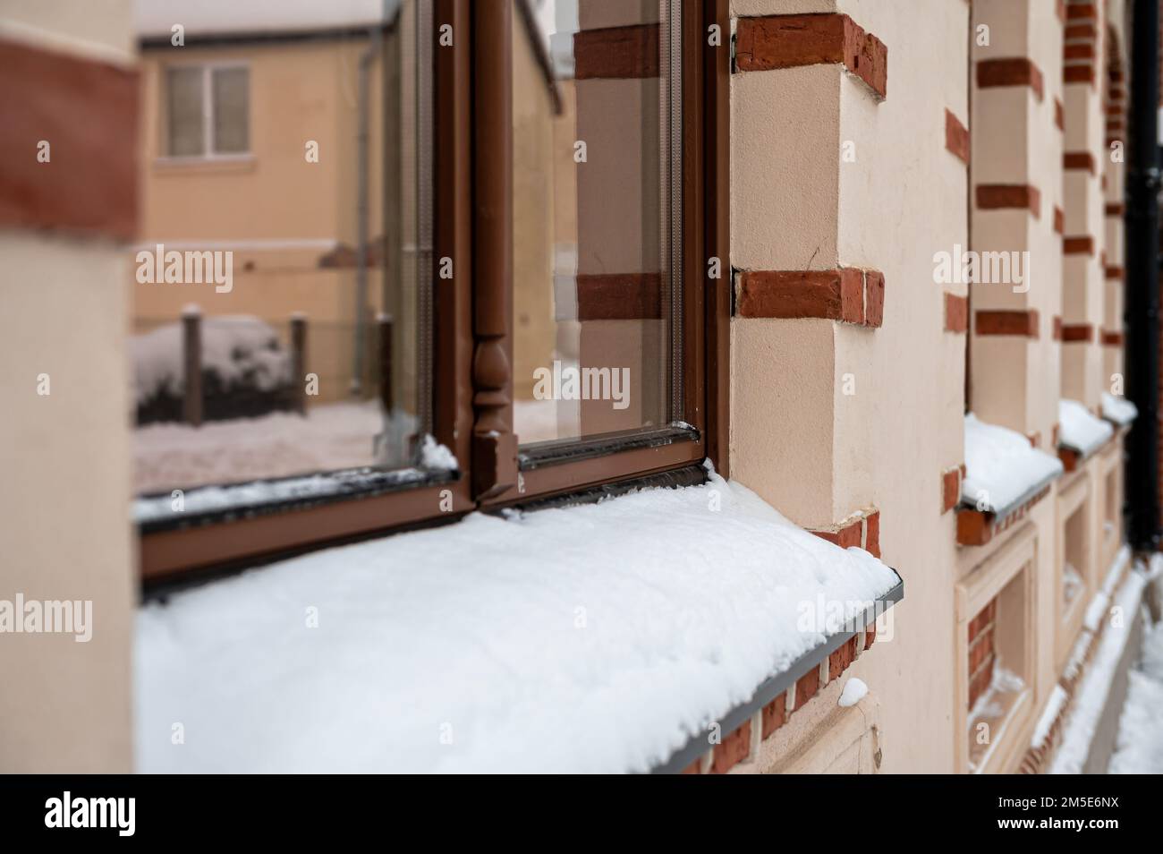 Window sill covered with heavy snow in winter, close-up of building ...