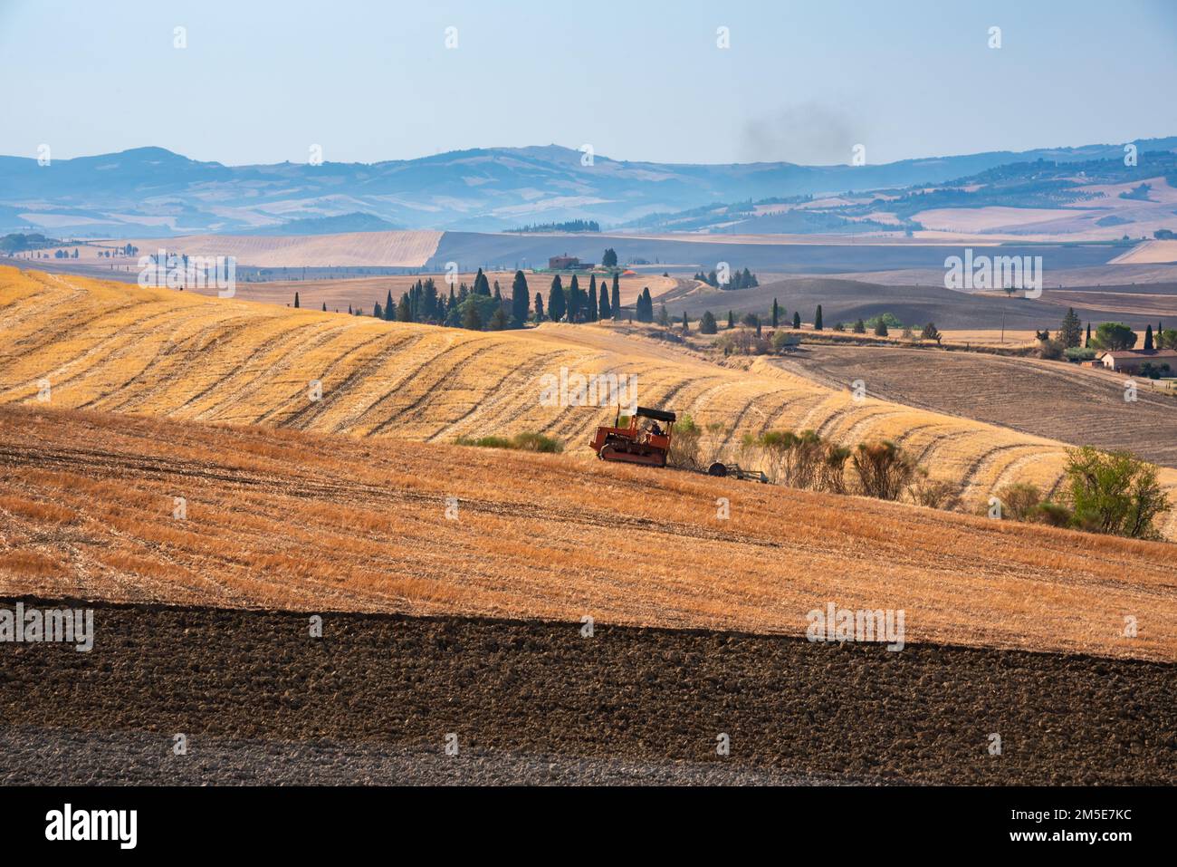 Tractor working on farming lands, countryside landscape in Tuscany ...