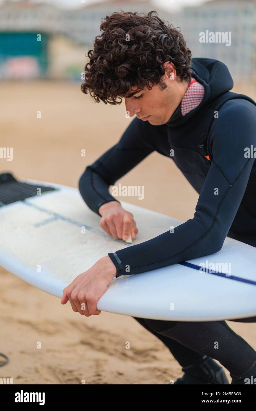 A Caucasian male surfer getting ready to go surfing in the ocean Stock ...