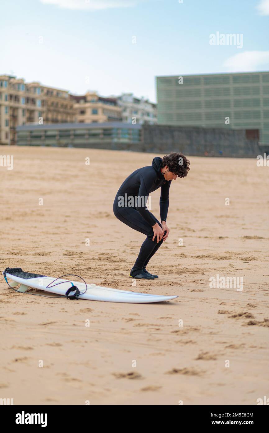 A Caucasian male surfer getting ready to go surfing in the ocean Stock ...