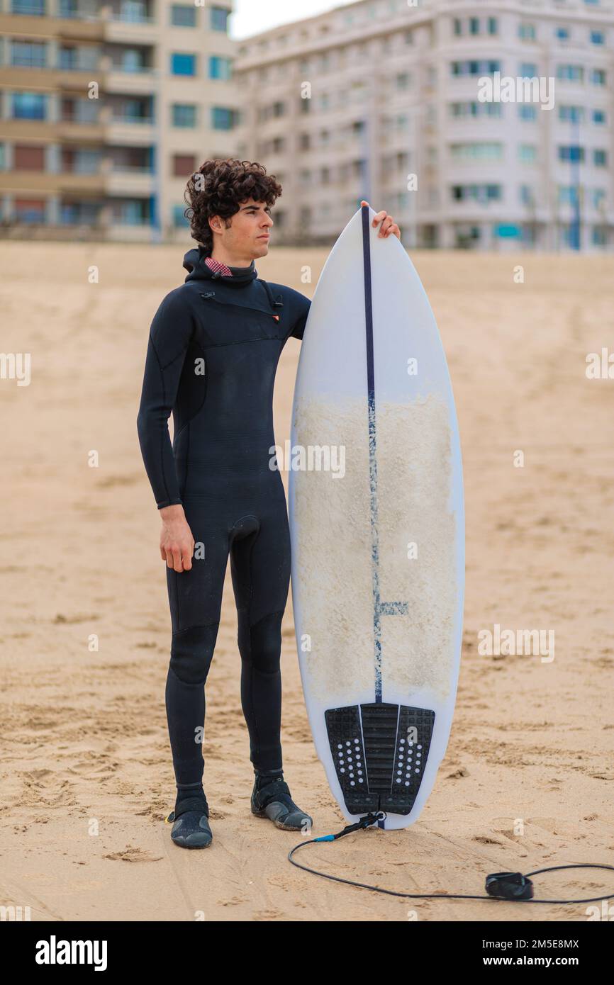 A Caucasian male surfer getting ready to go surfing in the ocean Stock Photo - Alamy