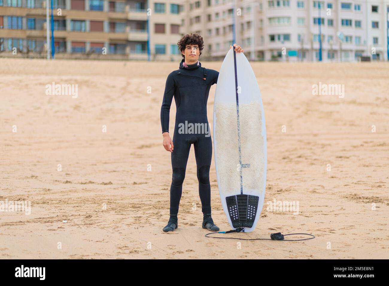 A Caucasian male surfer getting ready to go surfing in the ocean Stock ...
