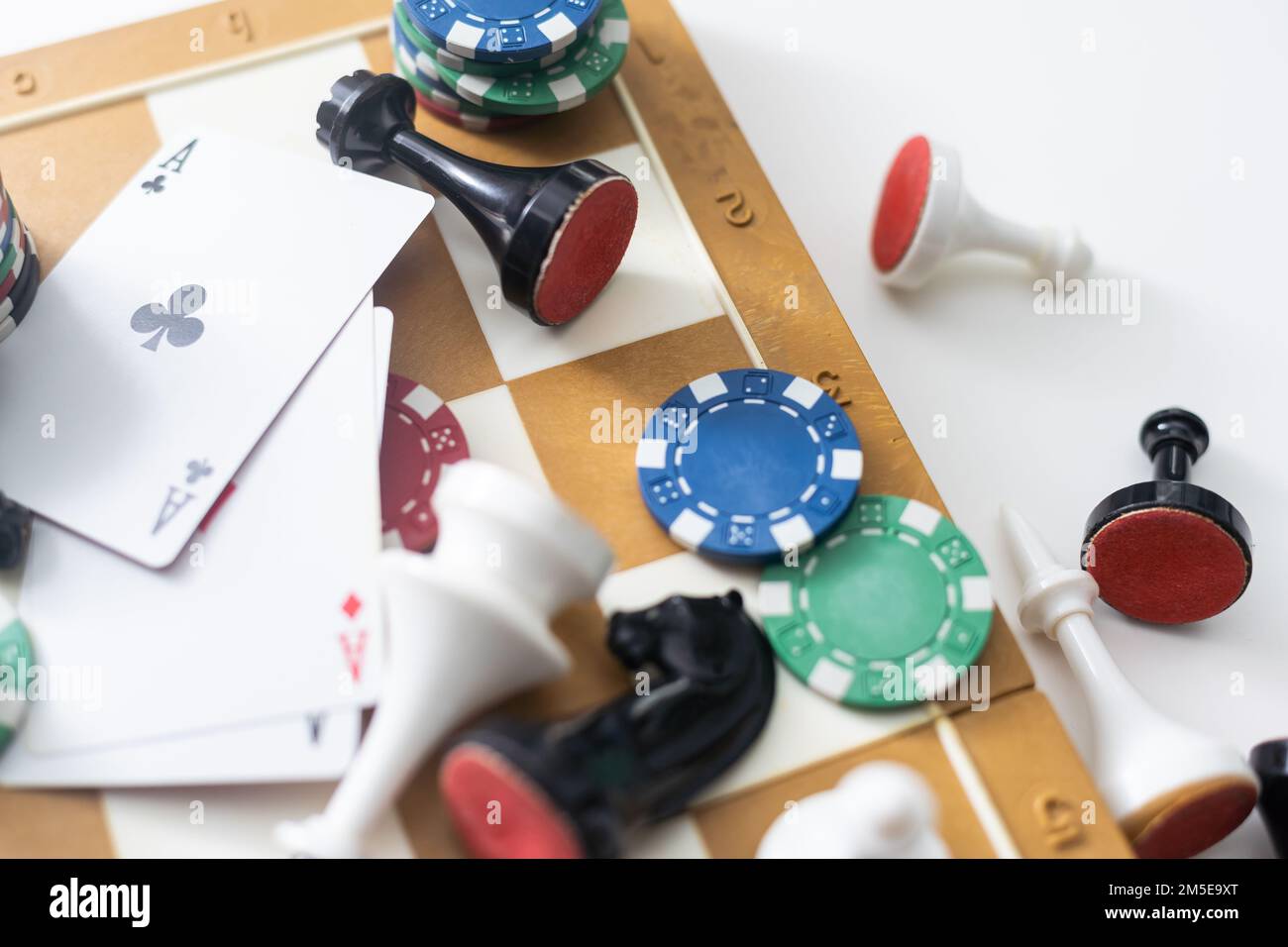 Wooden checkers, chess pieces, playing cards, board games on a light ...