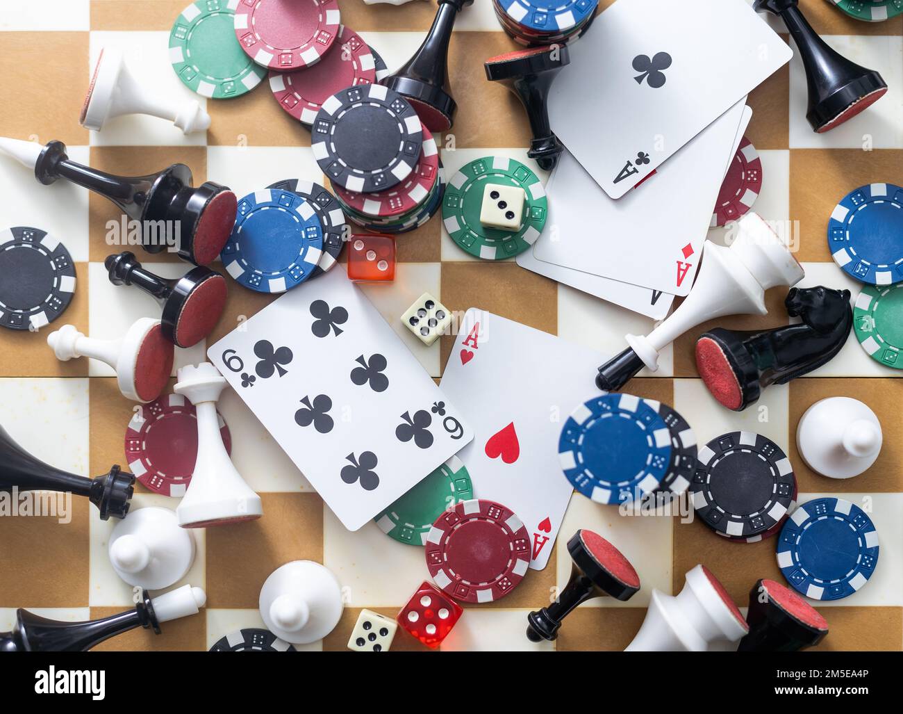 Wooden checkers, chess pieces, playing cards, board games on a light ...
