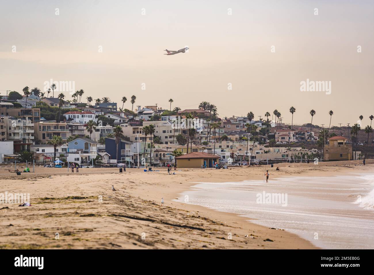 airplane flying over city at the beach Stock Photo - Alamy