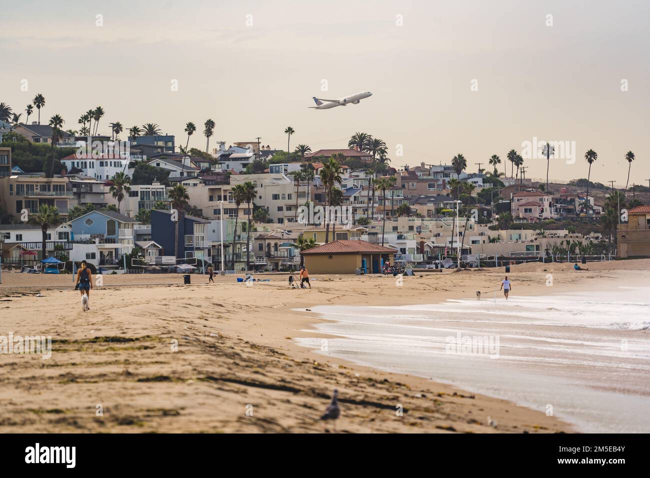 beach with small town and airplane taking off Stock Photo - Alamy
