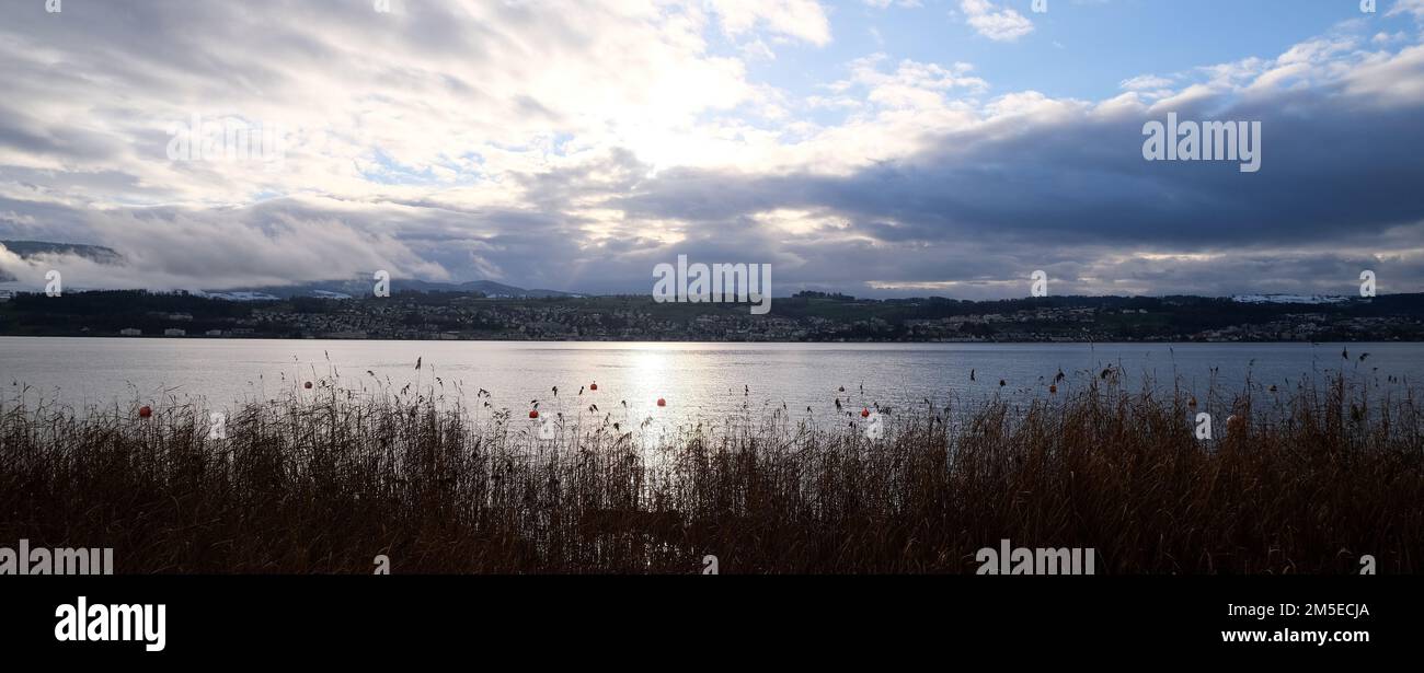 A panoramic shot of the half-cloudy sky with the sunshine reflecting in ...