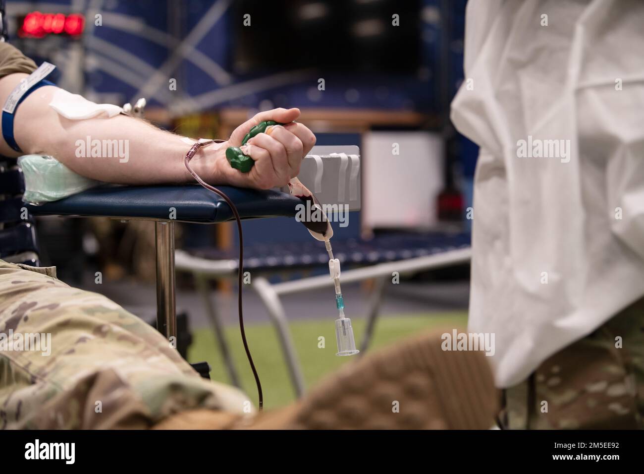 A U.S. service member clenches his fist while donating blood at The Hub ...