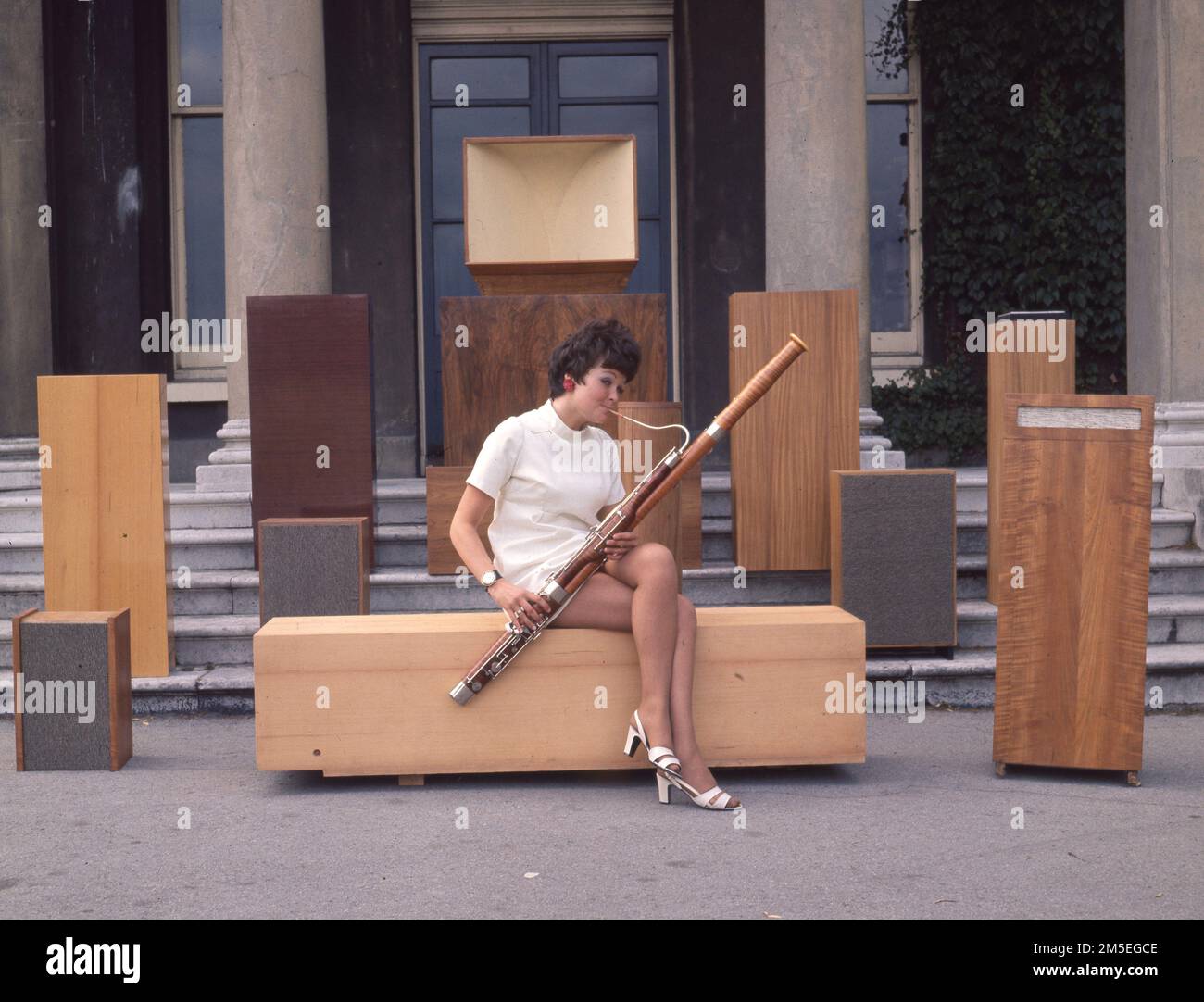 A model poses with a basoon by vintage large speakers. c1970. Photo by ...