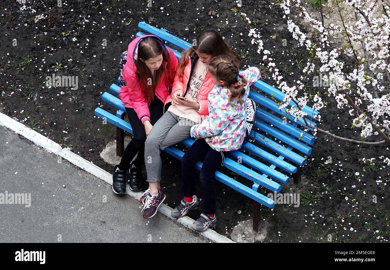 Three girls sitting on bench hi-res stock photography and images - Alamy