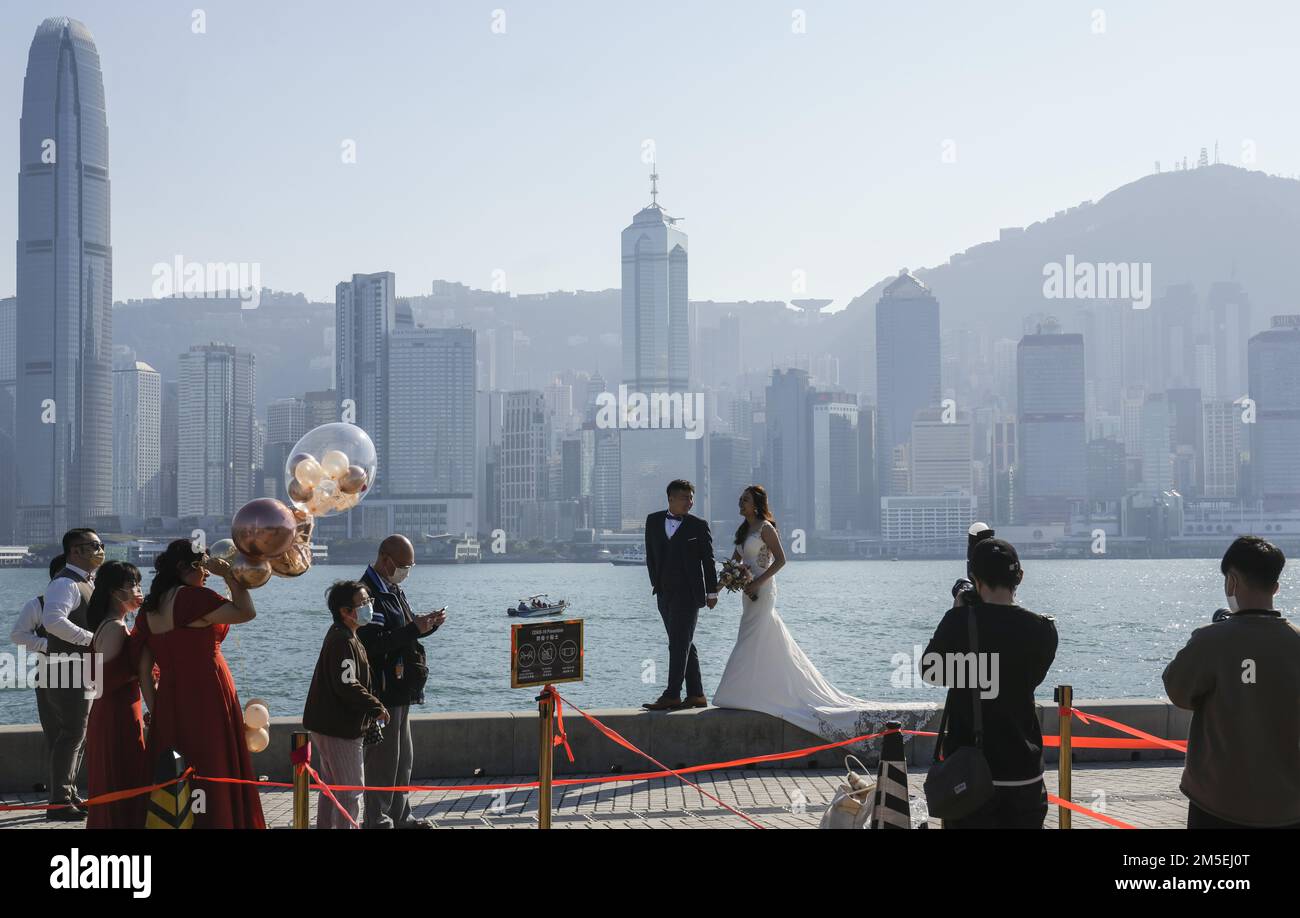 The bride and groom pose for pictures at the waterfront of West Kowloon ...