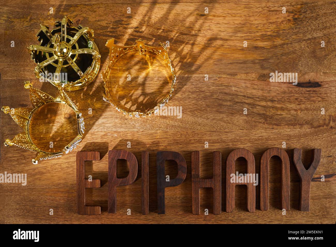 Happy Epiphany day. Three gold crowns on wooden background, symbol of ...