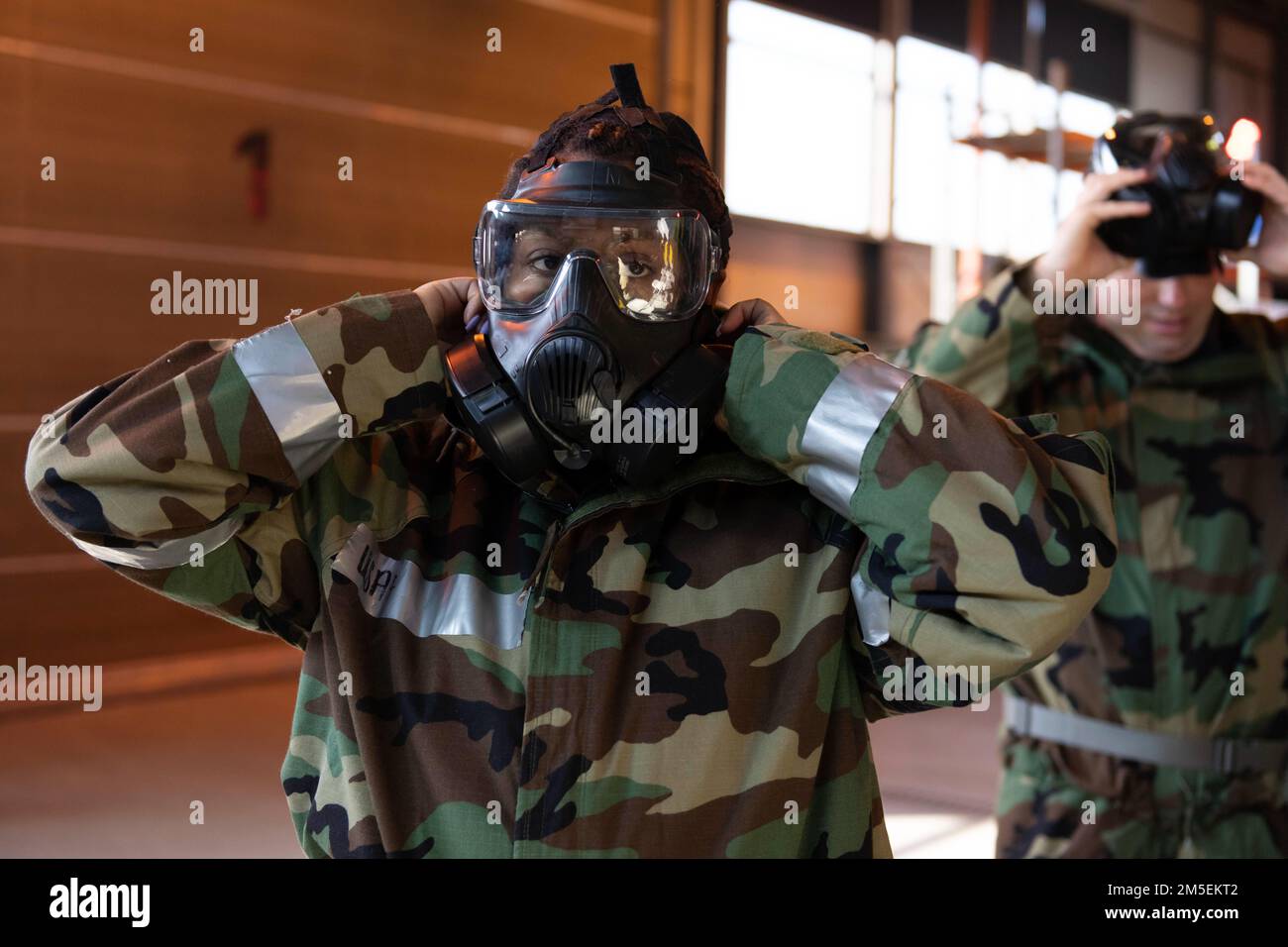 A U.S. Air Force Airman inspects her gas mask to ensure a proper seal ...