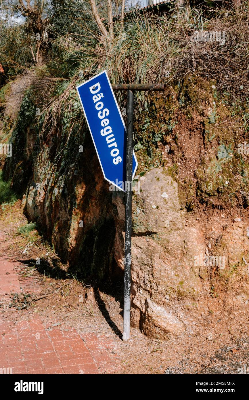 A broken sign post showing the location, town name in Portuguese Stock ...