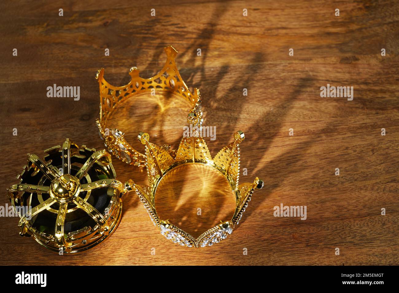 Happy Epiphany day. Three gold crowns on wooden background, symbol of ...