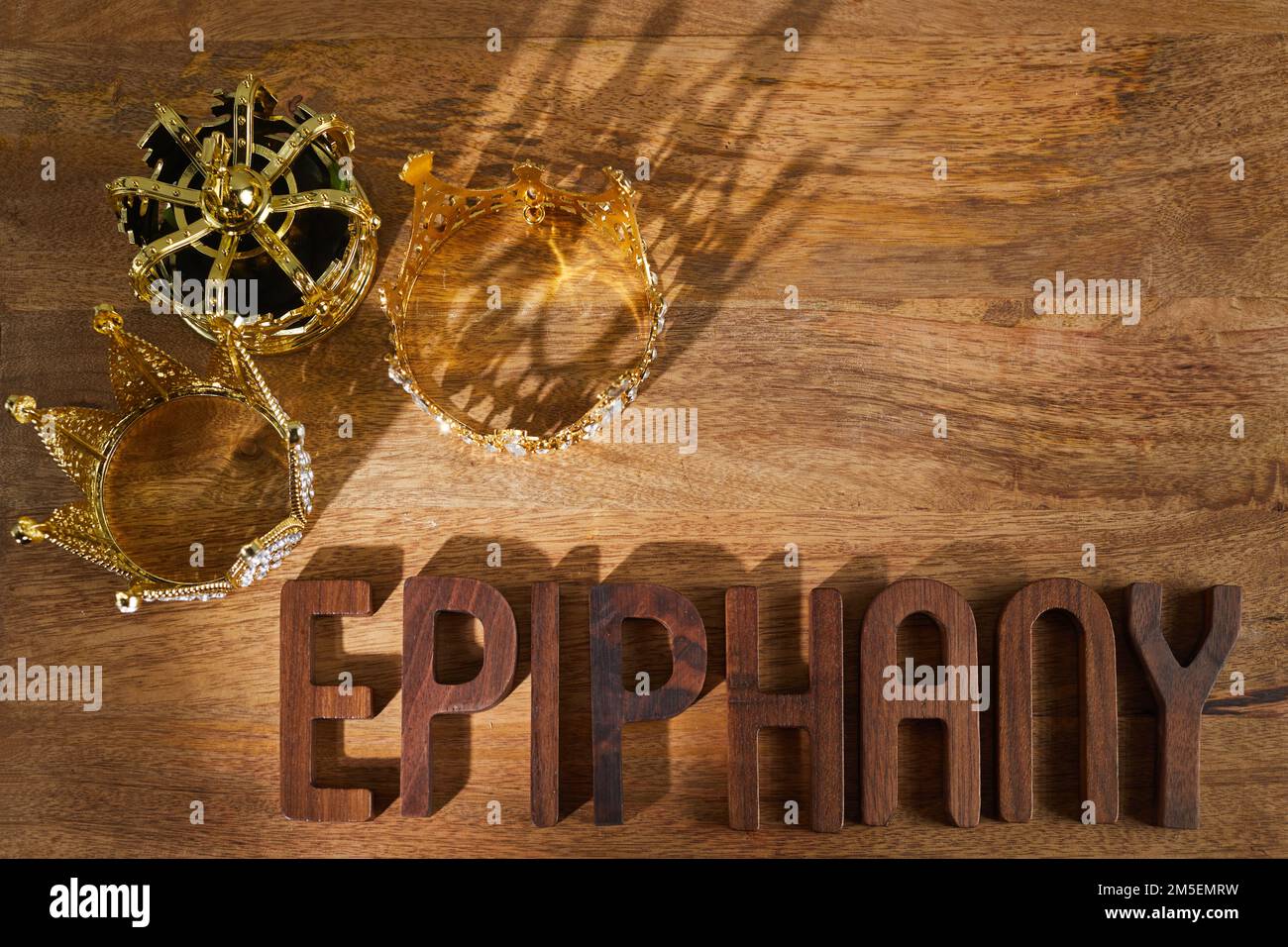 Happy Epiphany day. Three gold crowns on wooden background, symbol of ...