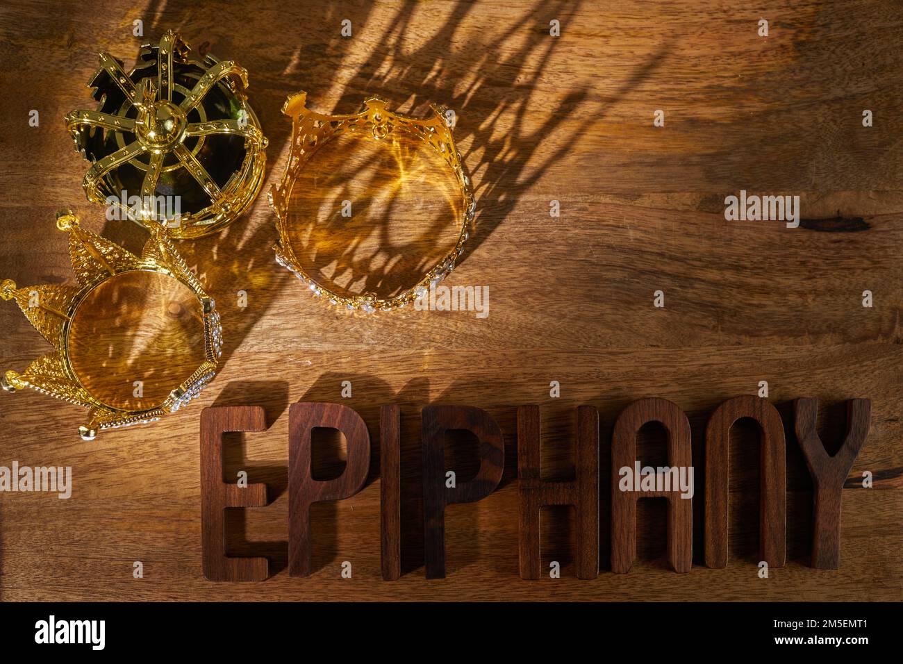 Happy Epiphany day. Three gold crowns on wooden background, symbol of ...