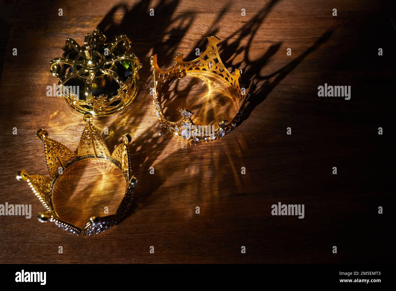 Happy Epiphany day. Three gold crowns on wooden background, symbol of ...