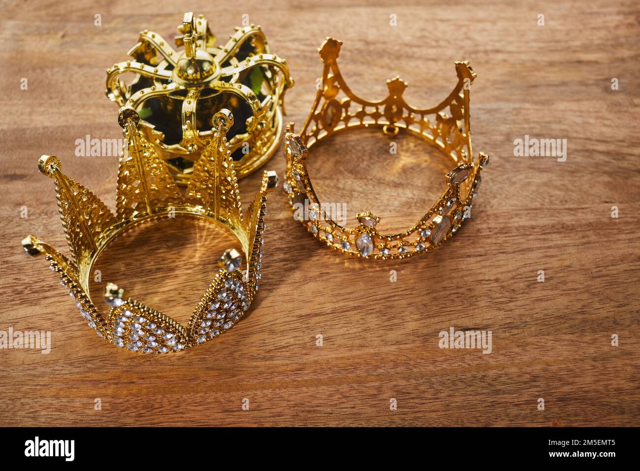 Happy Epiphany day. Three gold crowns on wooden background, symbol of ...