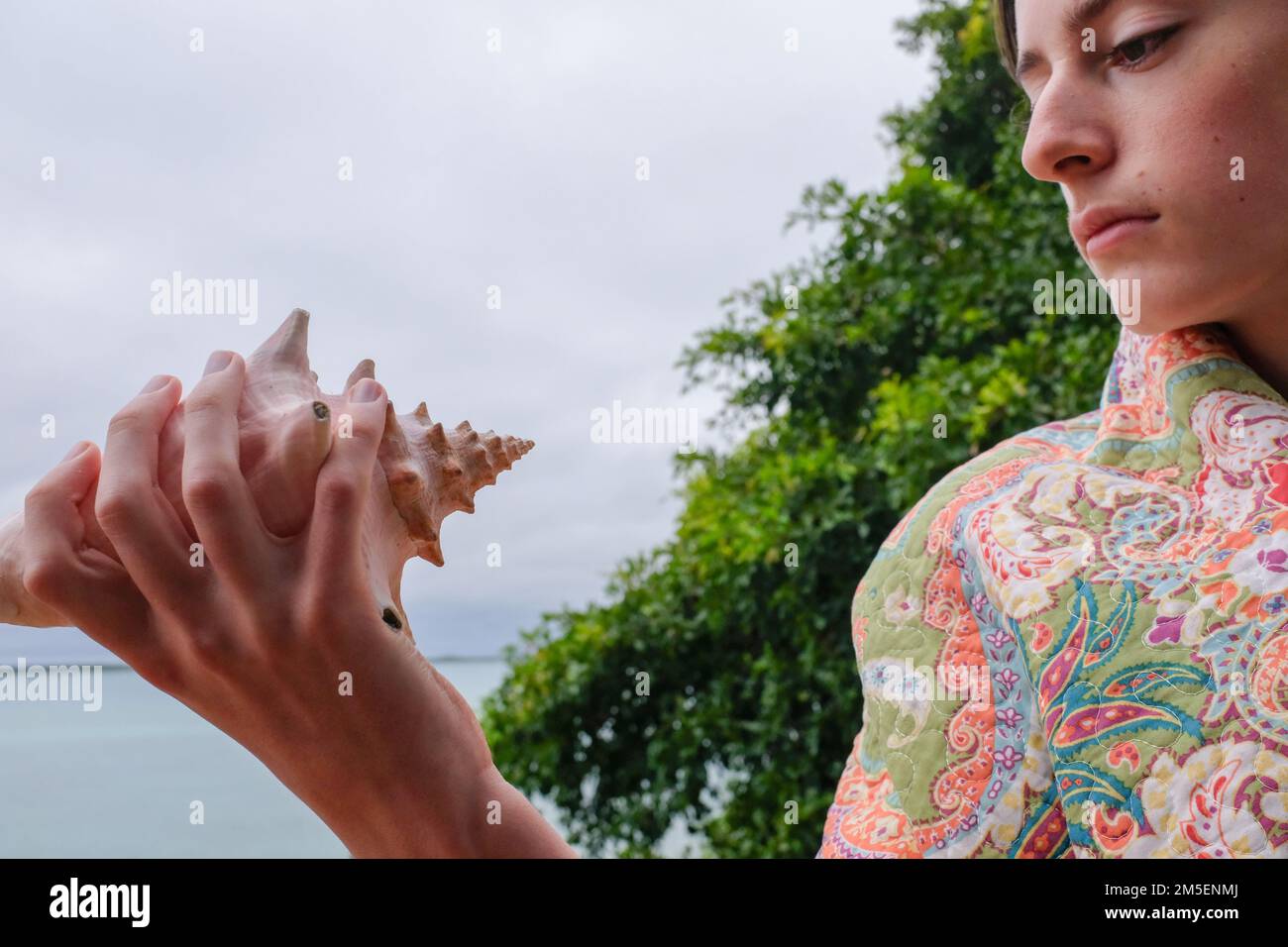 Caucasian teen holding a giant shell Stock Photo - Alamy