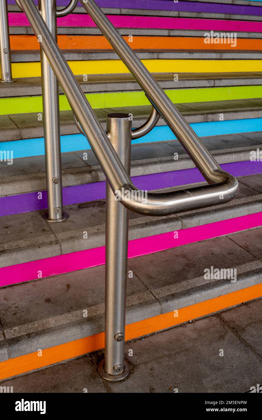 Steps with multi-coloured risers and a steel bannister Stock Photo - Alamy