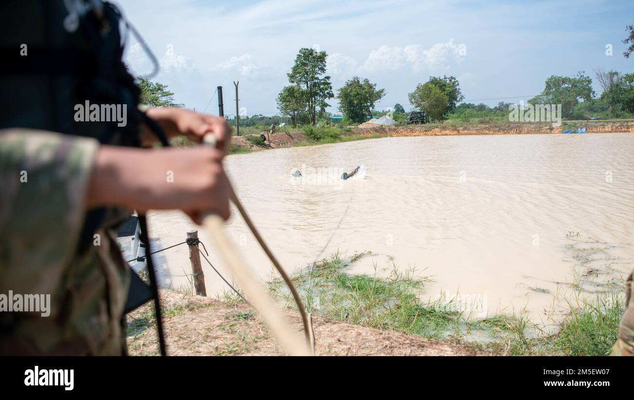 A U.S. Soldier and Royal Thai Army soldier pull a rope while swimming ...