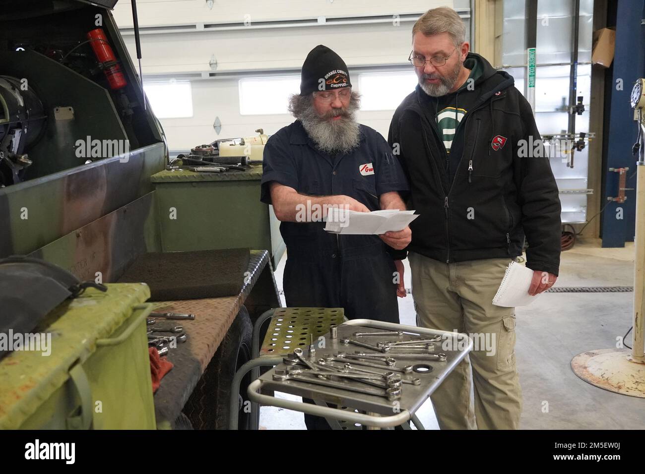 George Hafner, left) and Timothy Lawrence review the parts list for an air compressor unit at ...
