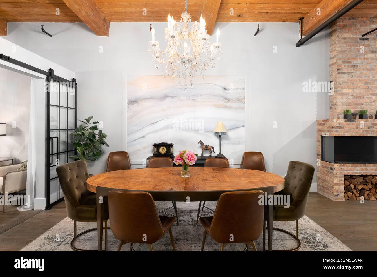 A loft dining room with an exposed wood ceiling, a chandelier above a ...