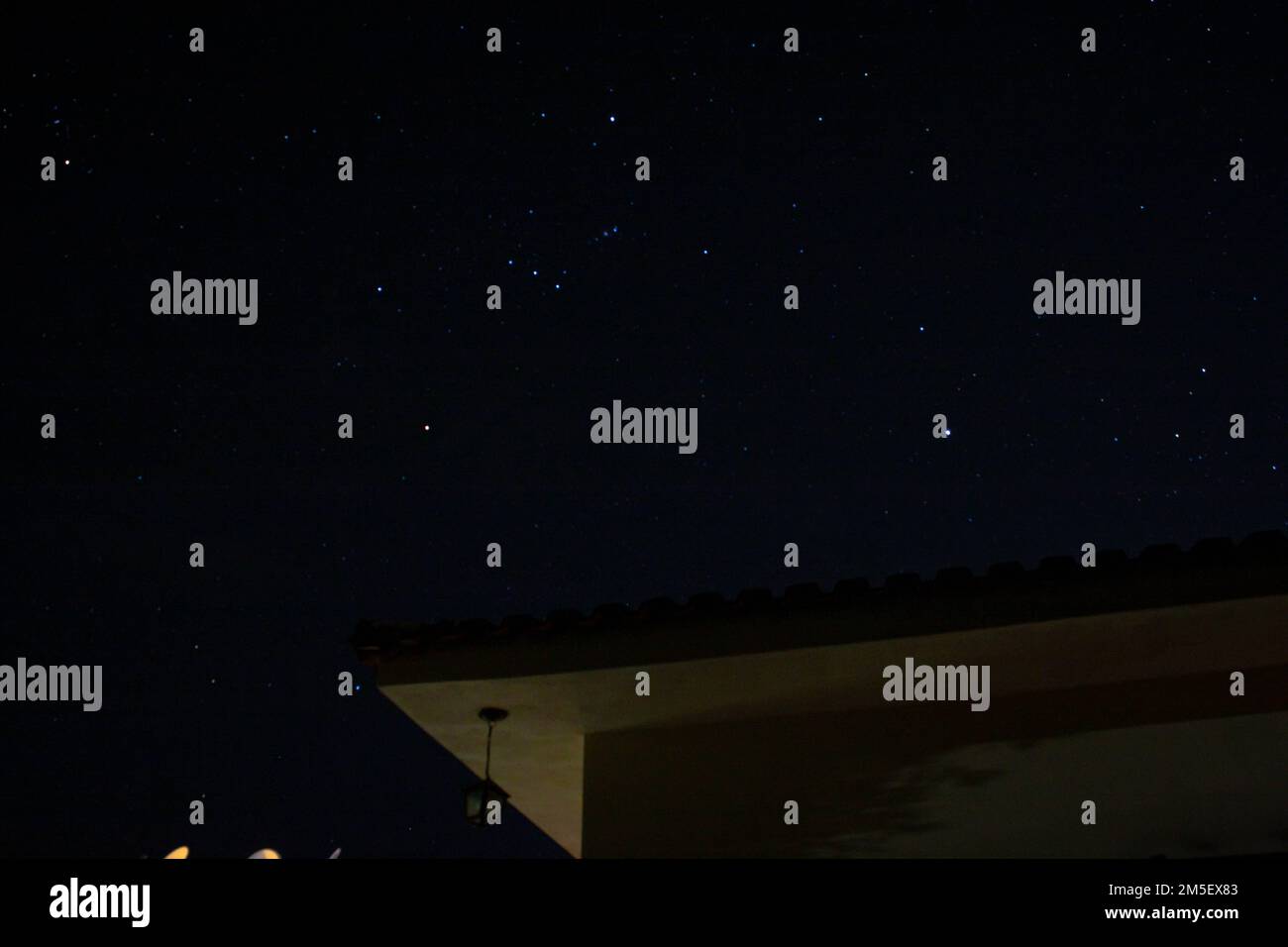 A scenic starry night sky seen above the roof of a home Stock Photo - Alamy