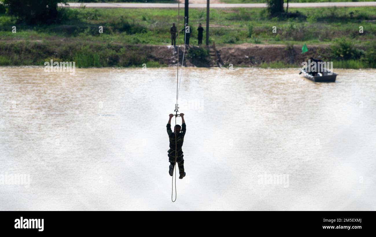 A soldier approaches the water while going down a zip-line as part of a ...