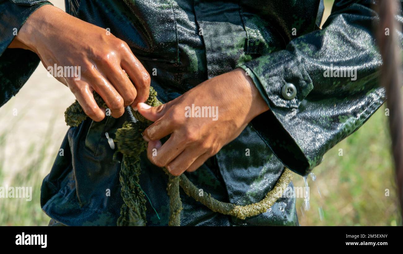 A Royal Thai Army soldier unties a safety line after a zip-line at the ...