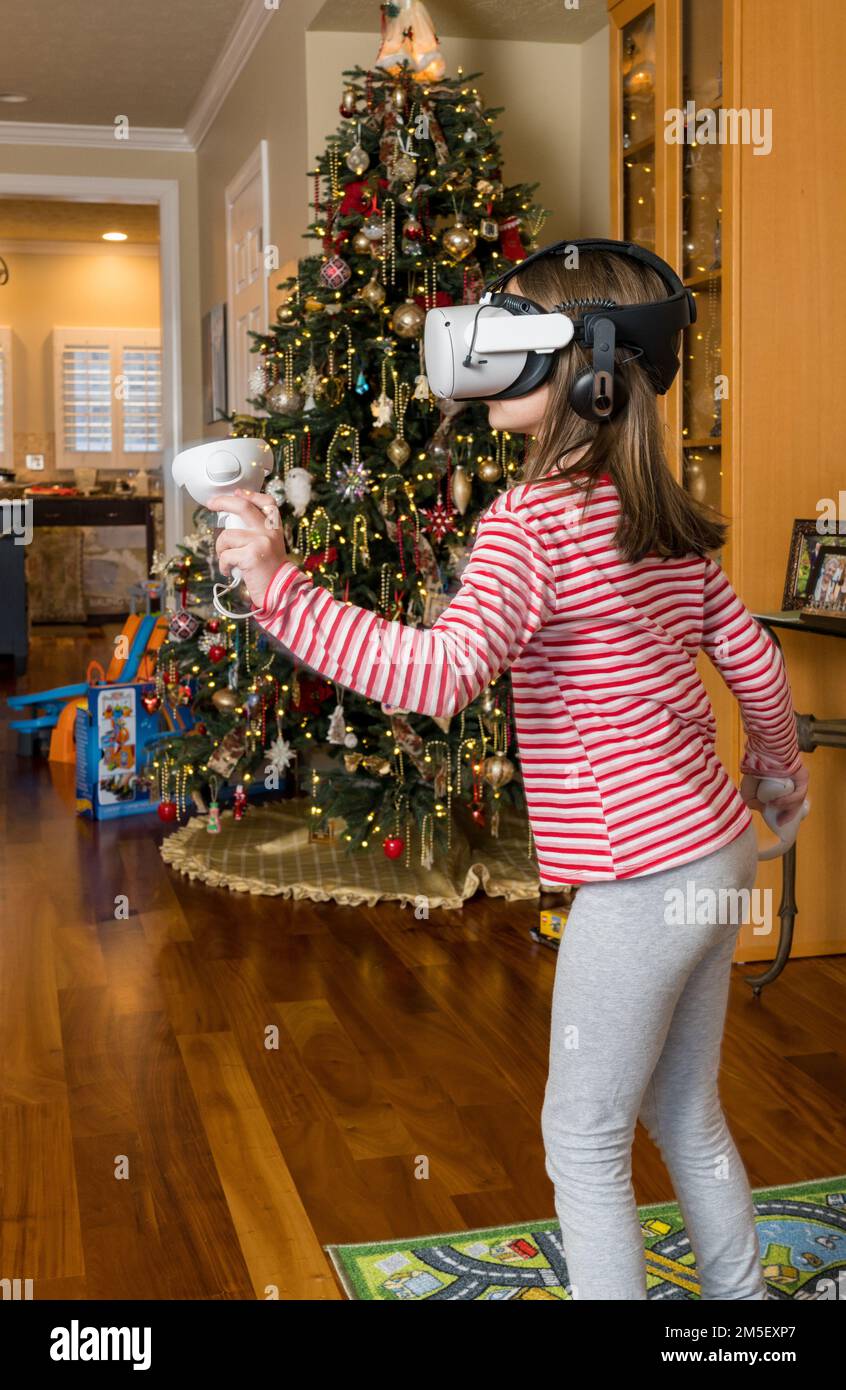 Young girl playing a game at Christmas on a modern virtual reality VR ...